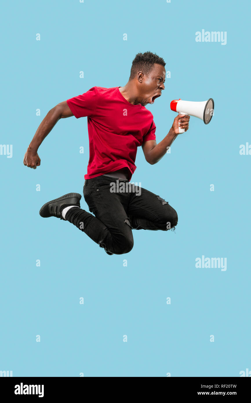 Soccer fan jumping on orange background. The young african man as ...