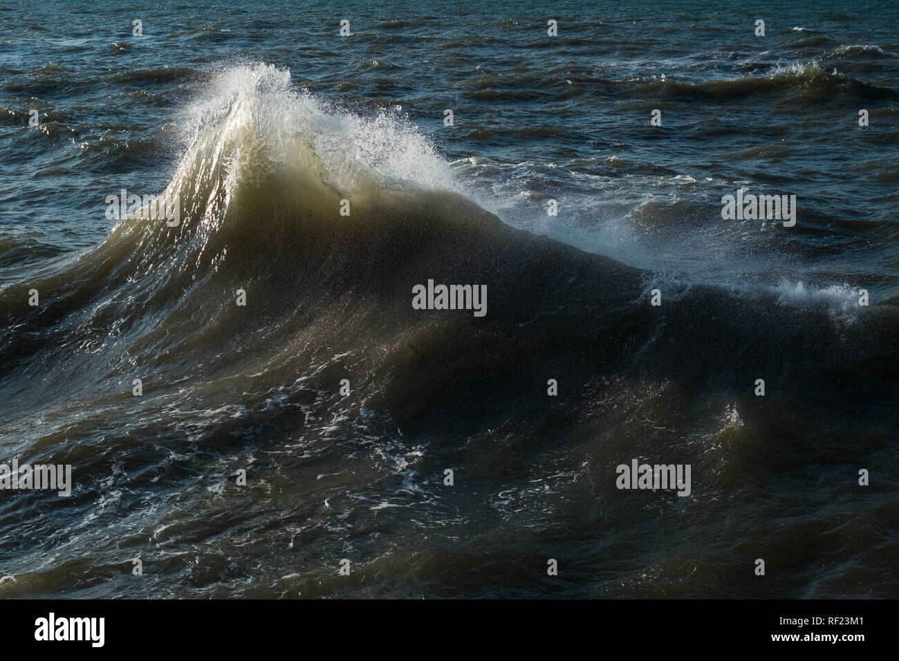 Splash of ocean waves against the backdrop of calm water Stock Photo ...