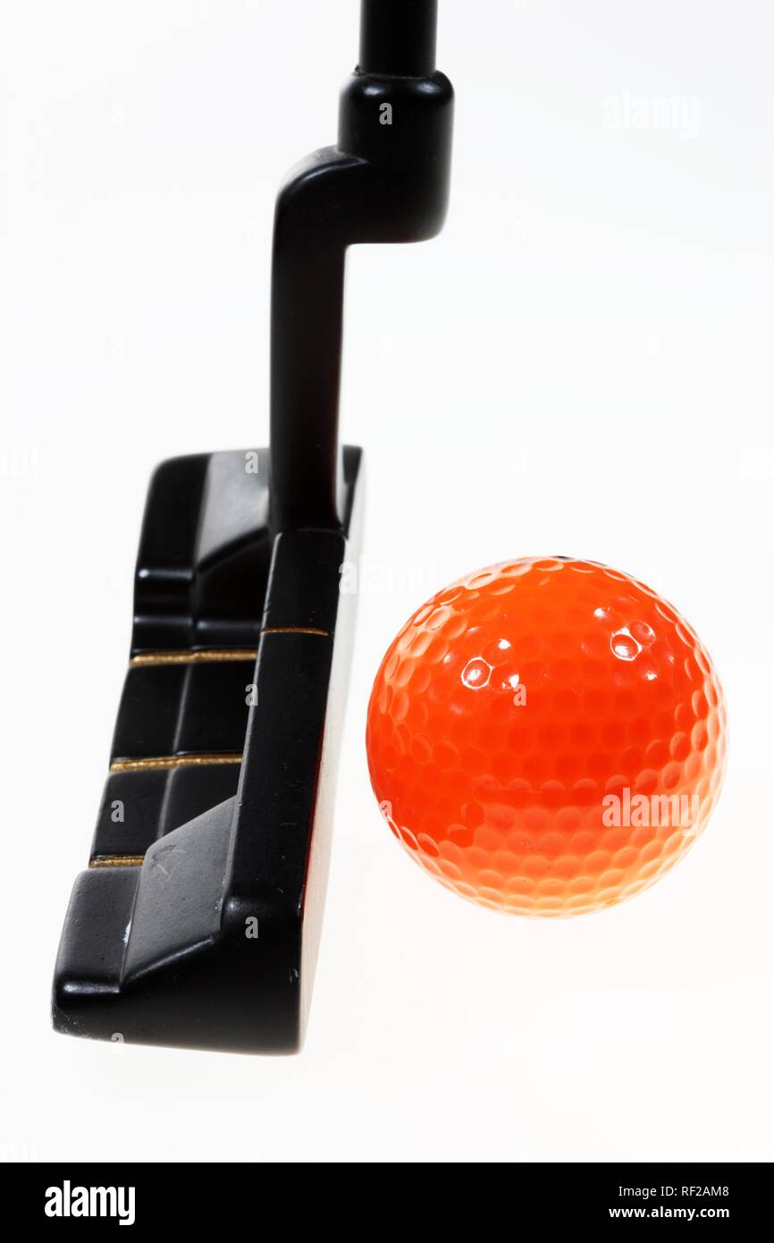 Bright orange golf ball beside head of black putter Stock Photo - Alamy