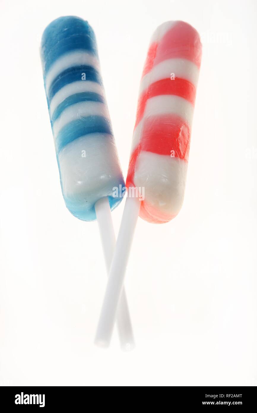 Two hard sugar candy lollipops on sticks, one blue and white striped ...