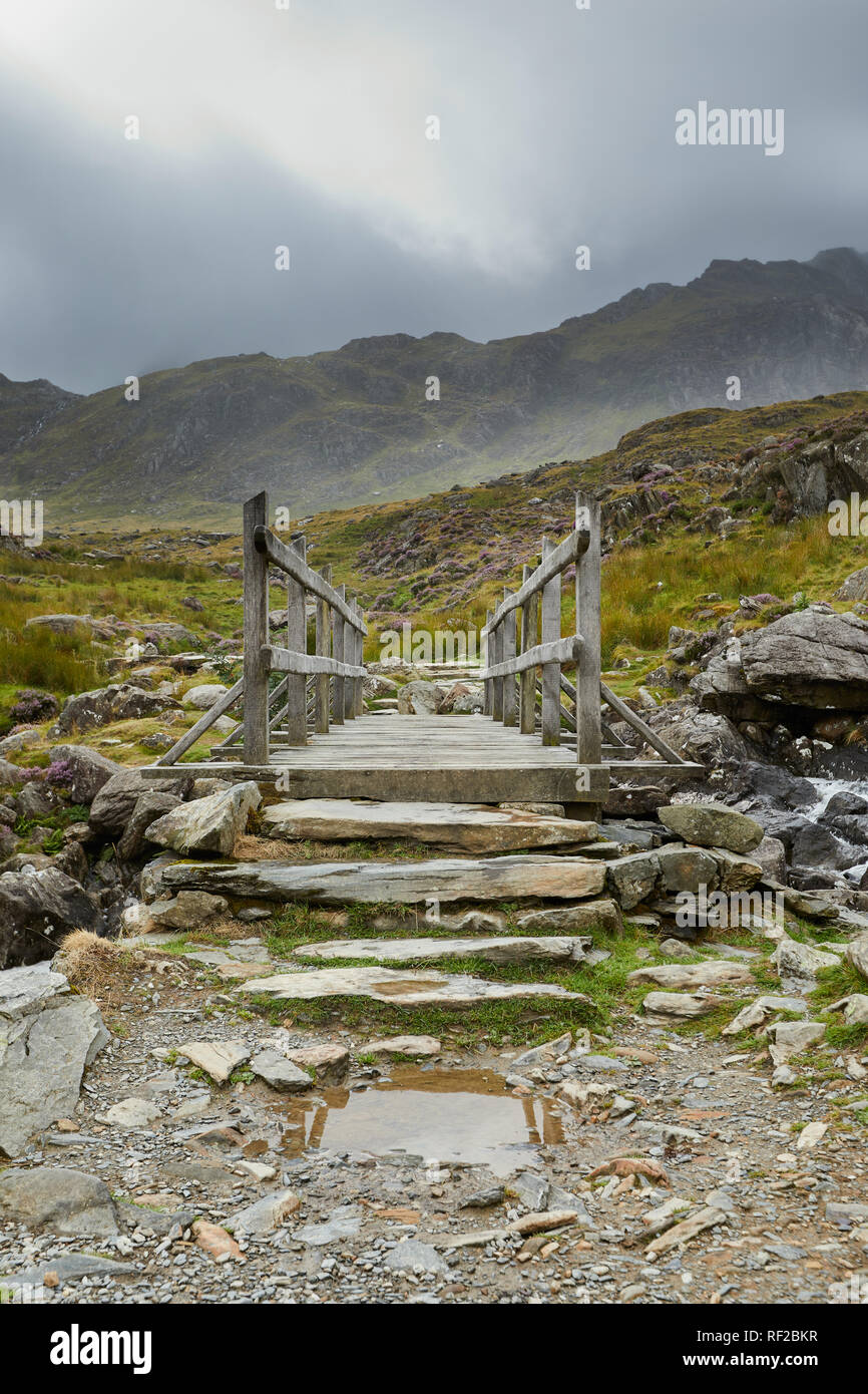 A foot bridge over a mountain waterfall near Llyn Idwal, Snowdonia ...