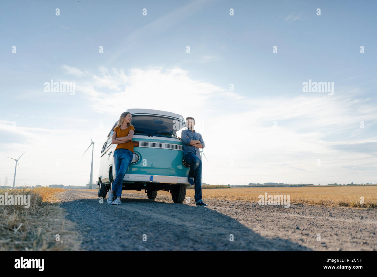 Happy couple standing at camper van in rural landscape Stock Photo - Alamy