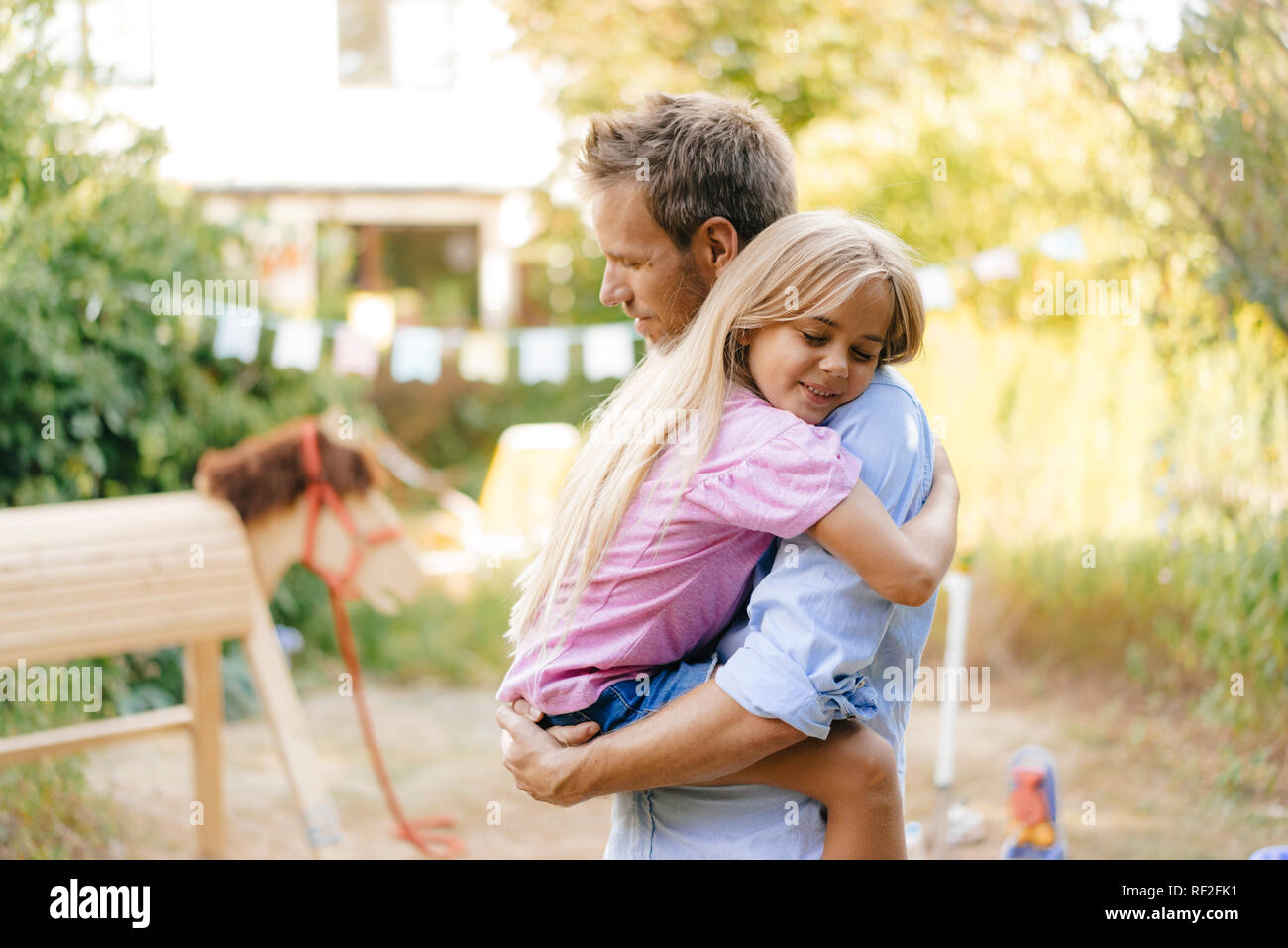 Father cuddling with daughter in garden Stock Photo - Alamy