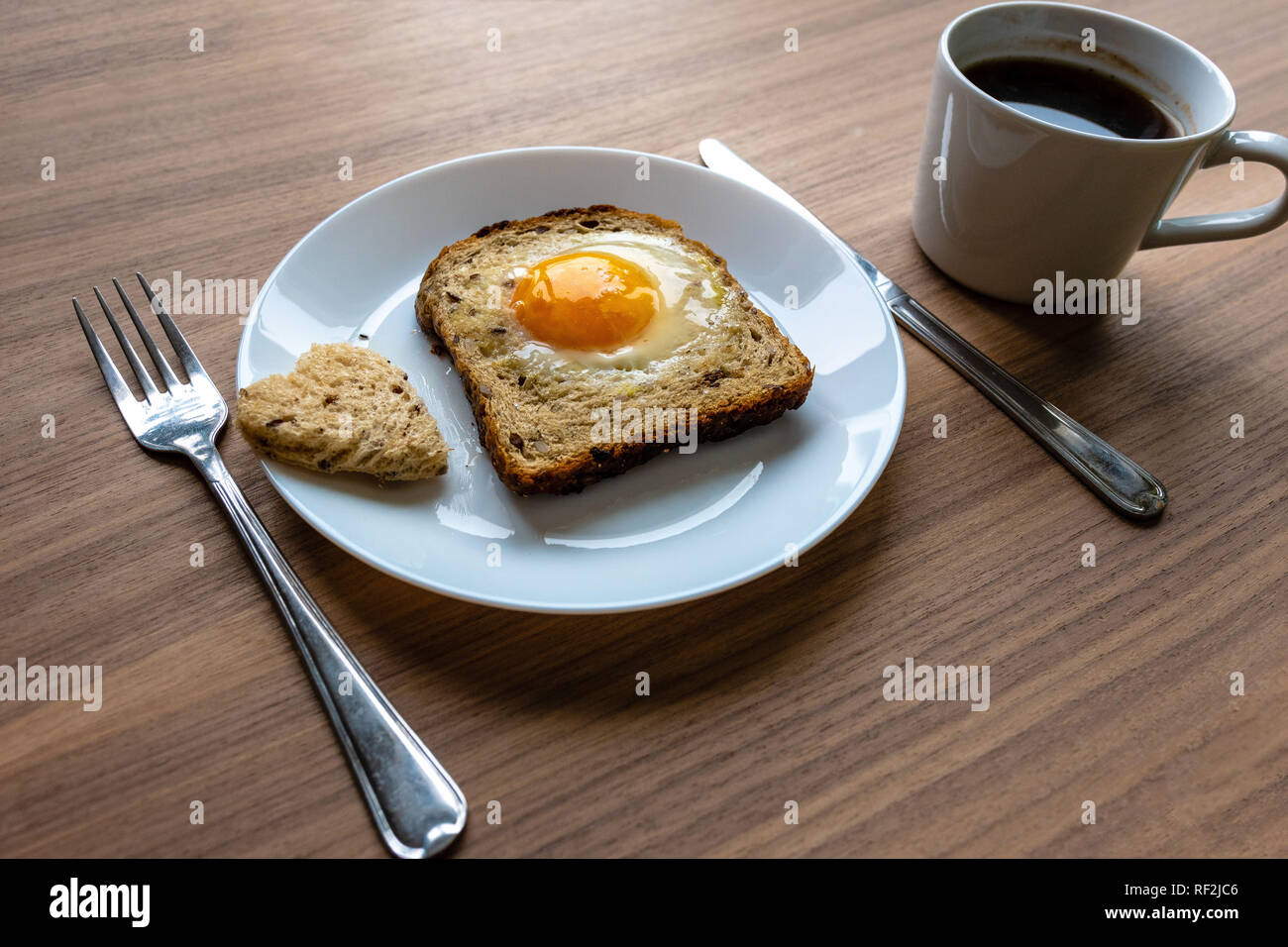 Breakfast concept. White plate with hearts of bread, baked bread and ...