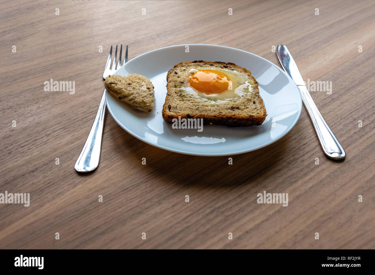 Breakfast concept. White plate with hearts of bread, baked bread and ...