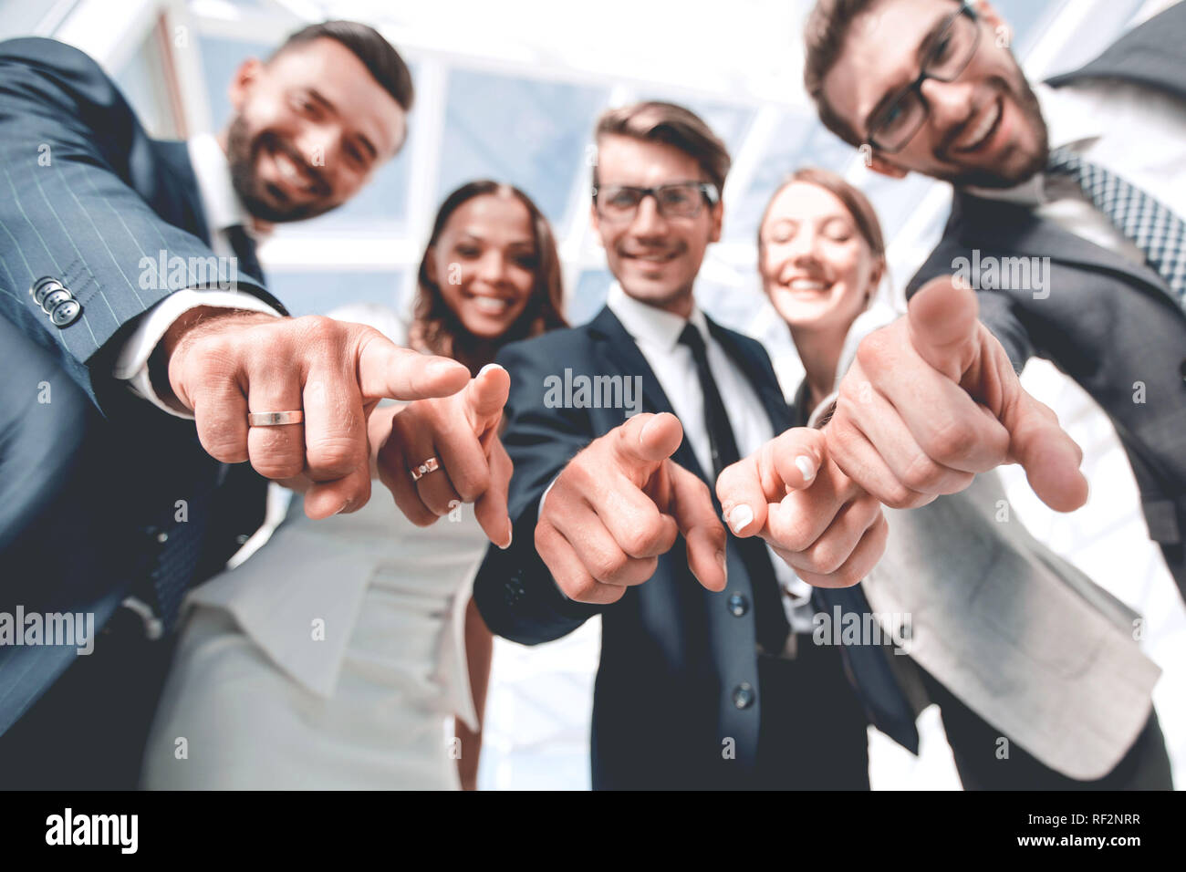 close up.smiling business team pointing at you Stock Photo - Alamy