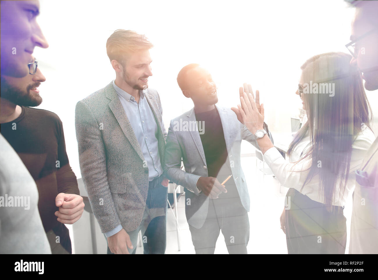Group of young colleagues giving each other a high five Stock Photo - Alamy