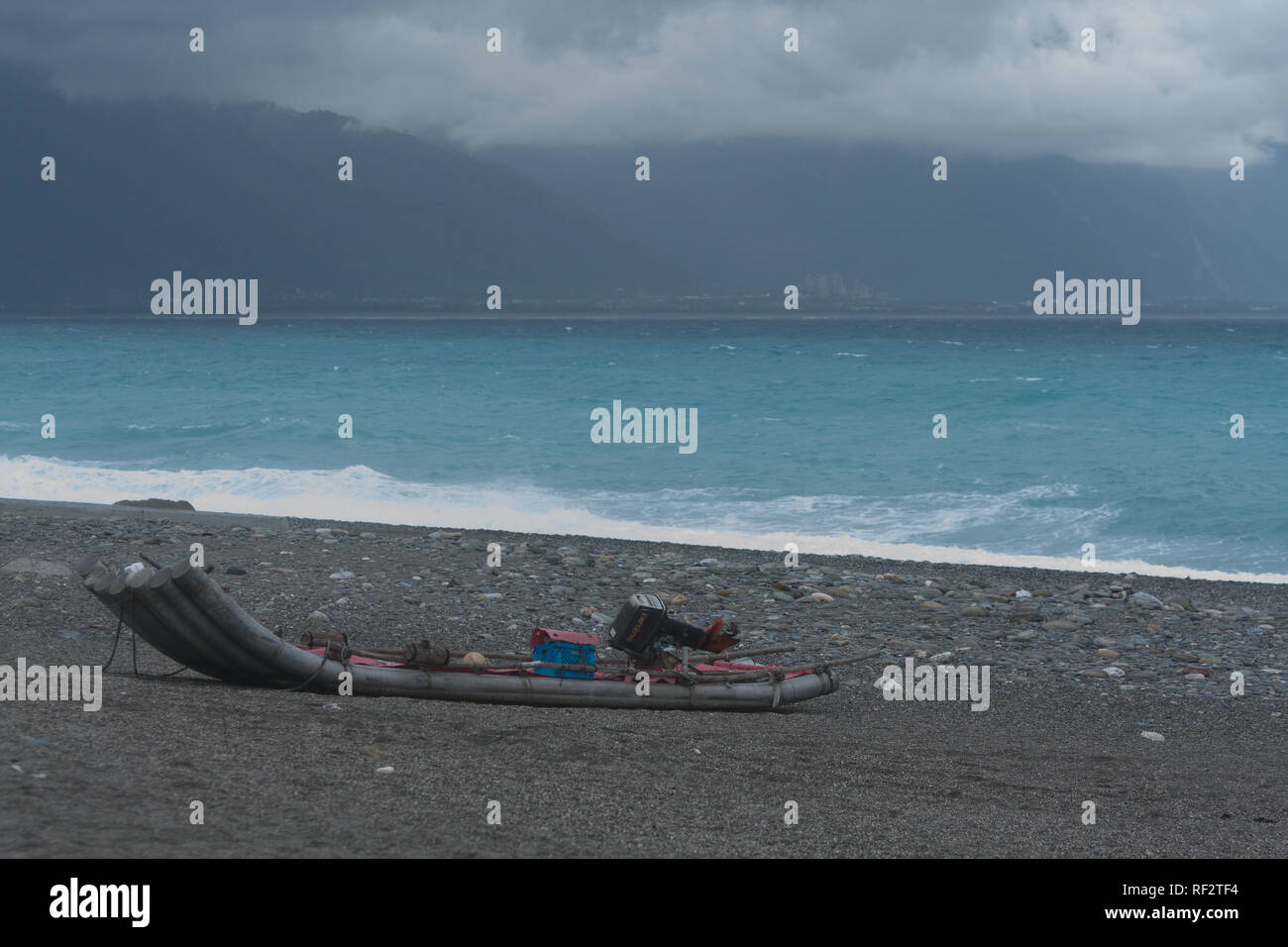Small plastic raft, clear azure waters washing over pebble beach with ...