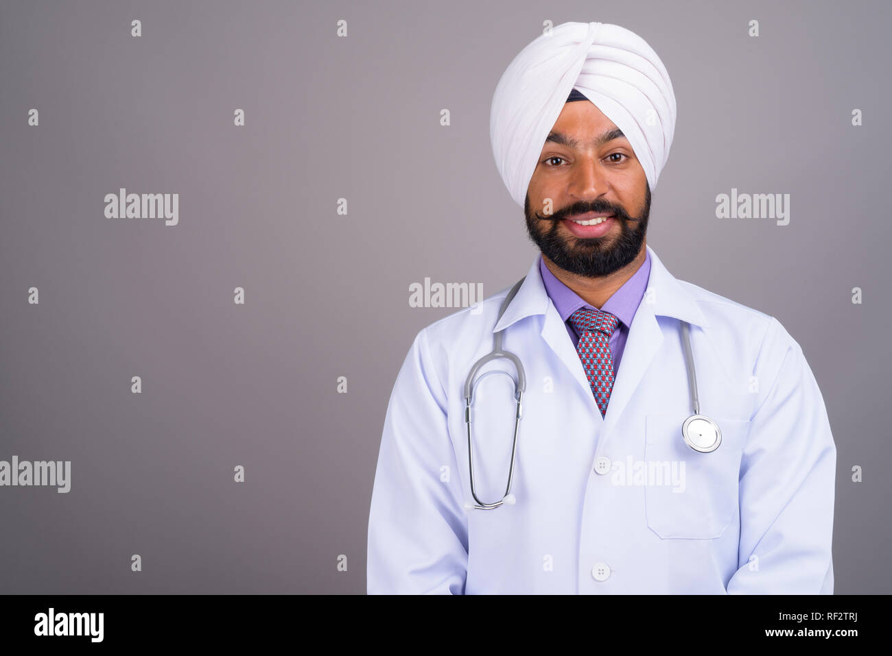 Portrait of young Indian Sikh man doctor smiling Stock Photo - Alamy