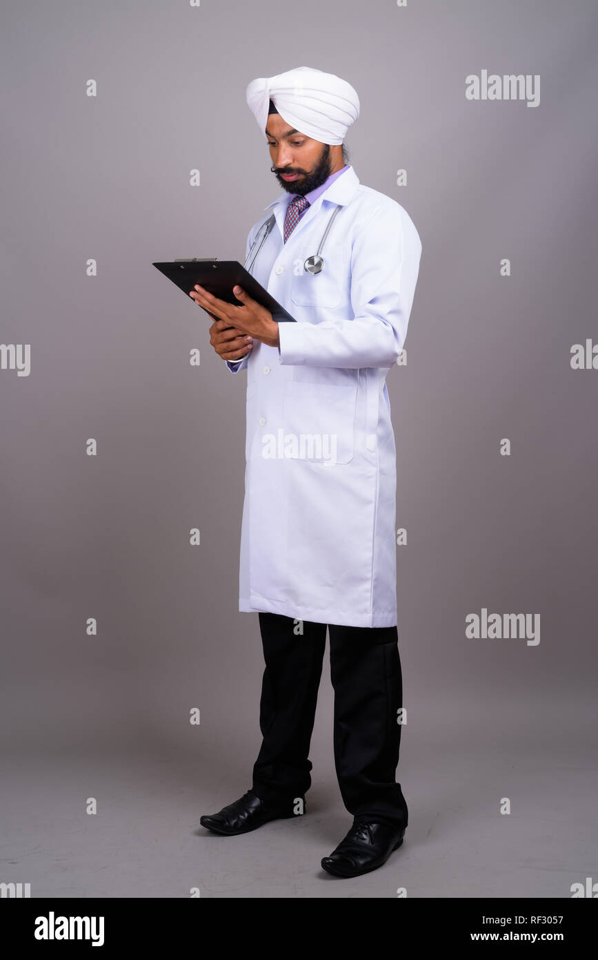 Portrait of young Indian Sikh man doctor holding clipboard Stock Photo ...
