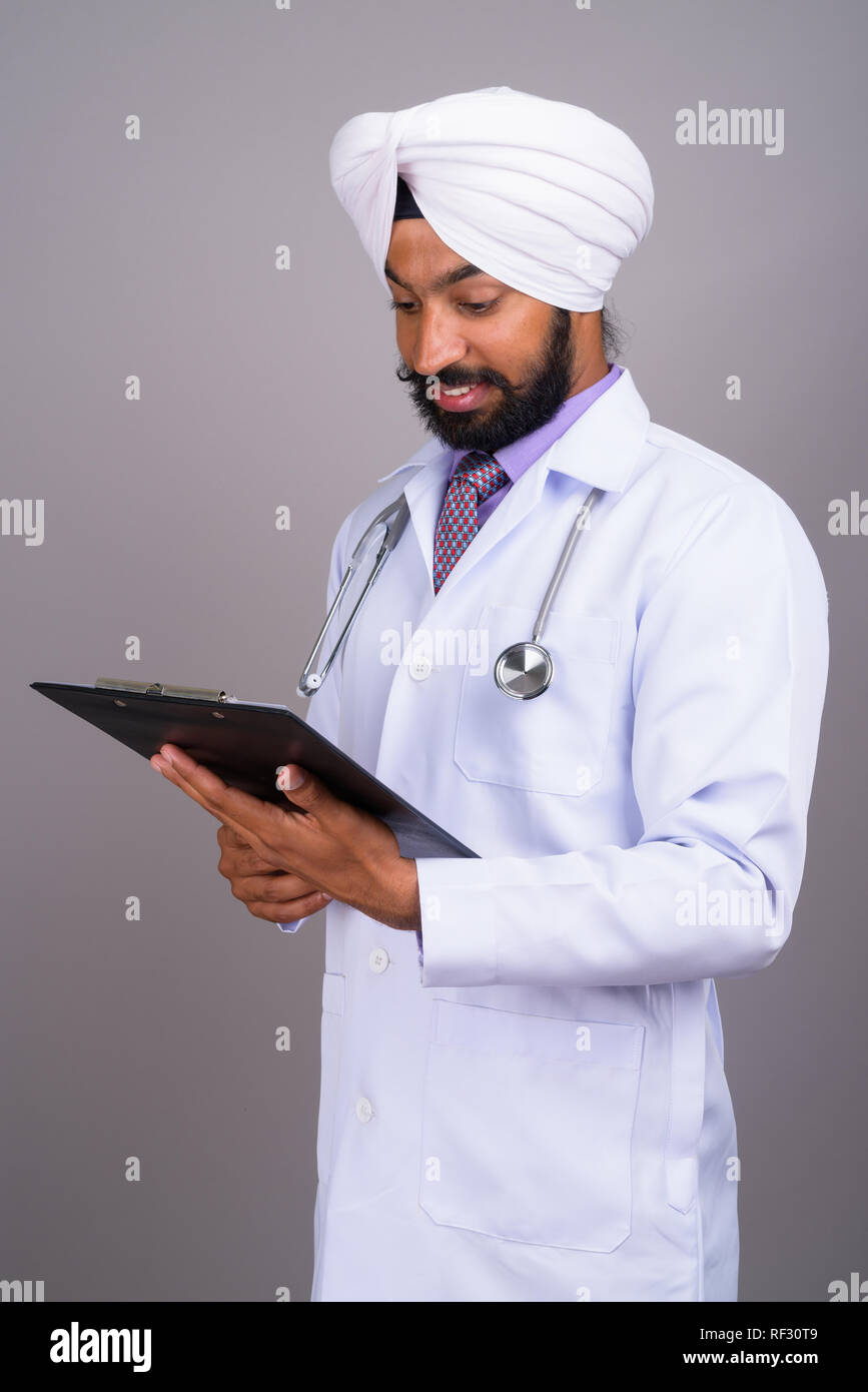 Portrait of young Indian Sikh man doctor holding clipboard Stock Photo ...