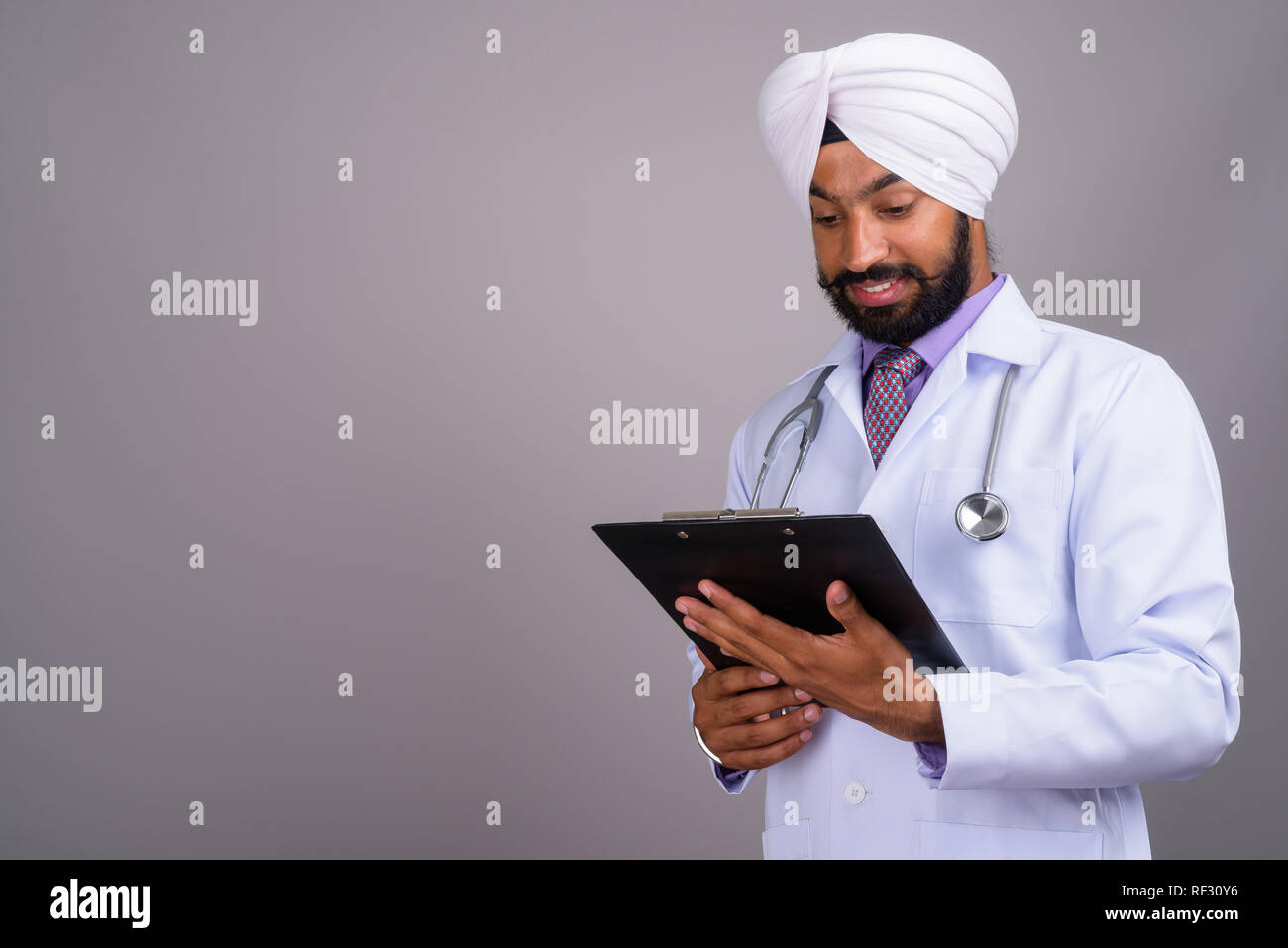 Portrait of young Indian Sikh man doctor smiling Stock Photo - Alamy