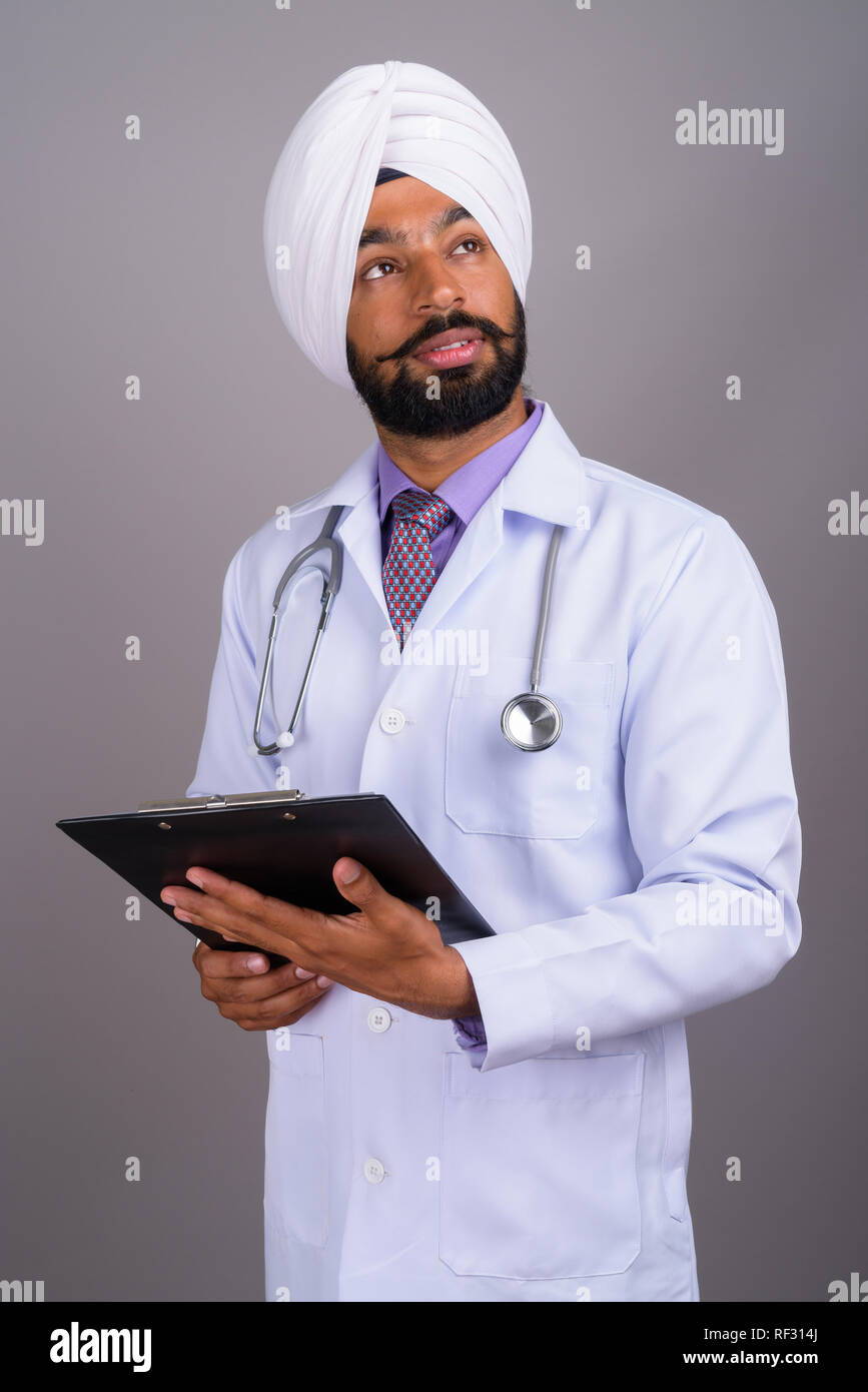 Portrait of young Indian Sikh man doctor holding clipboard Stock Photo ...