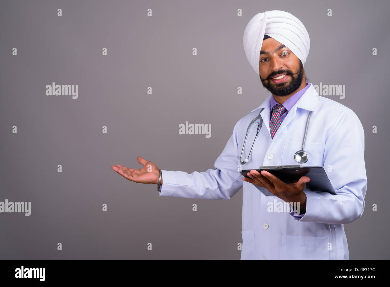 Portrait of young Indian Sikh man doctor smiling Stock Photo - Alamy