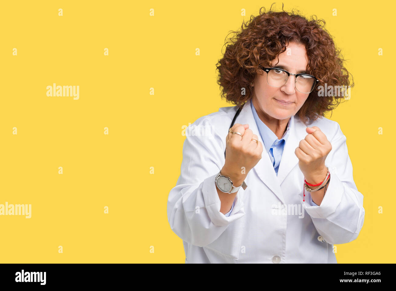 Middle ager senior doctor woman over isolated background Ready to fight ...