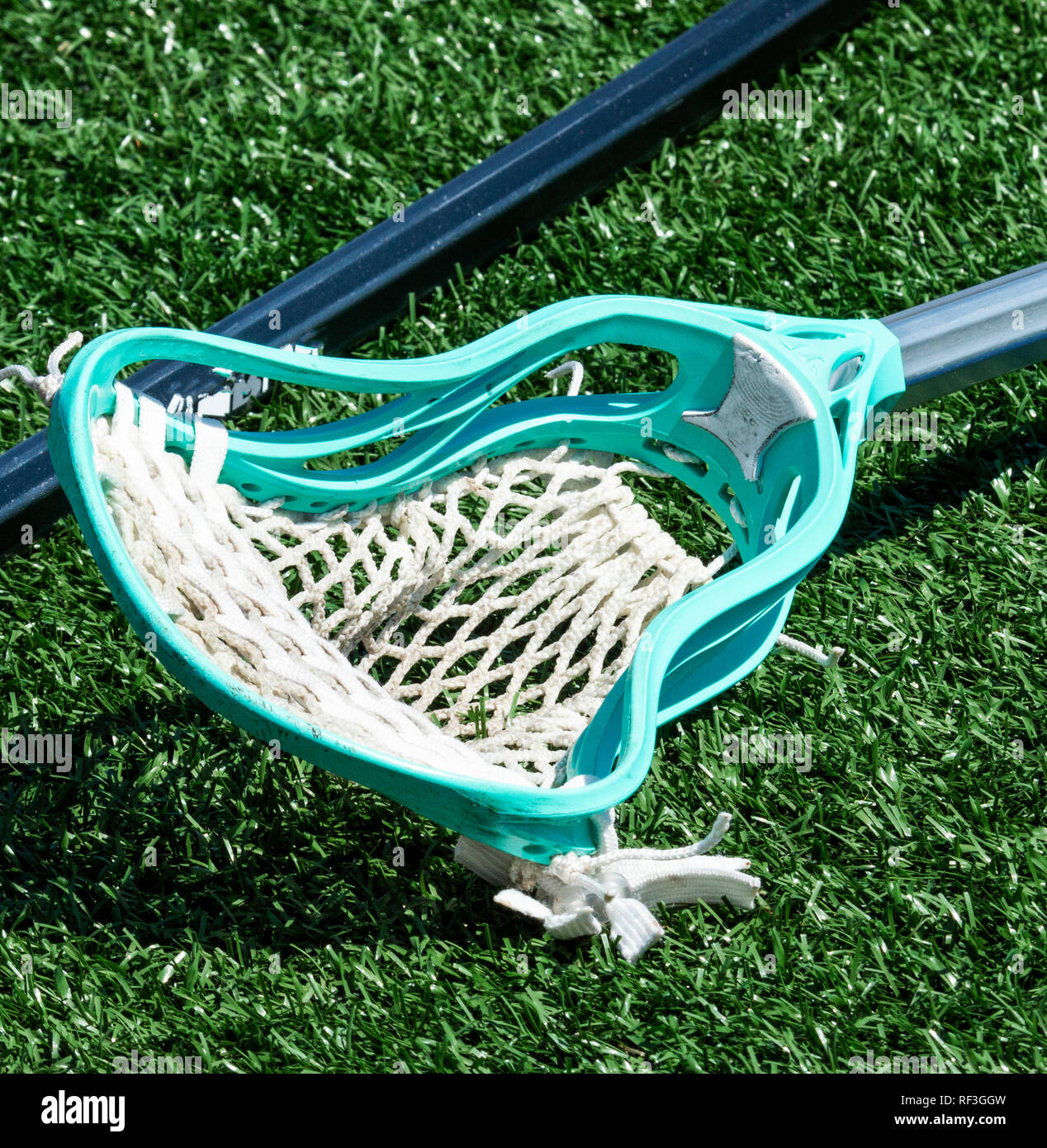 A high school boys aqua blue lacrosse stick lying on the ground Stock ...