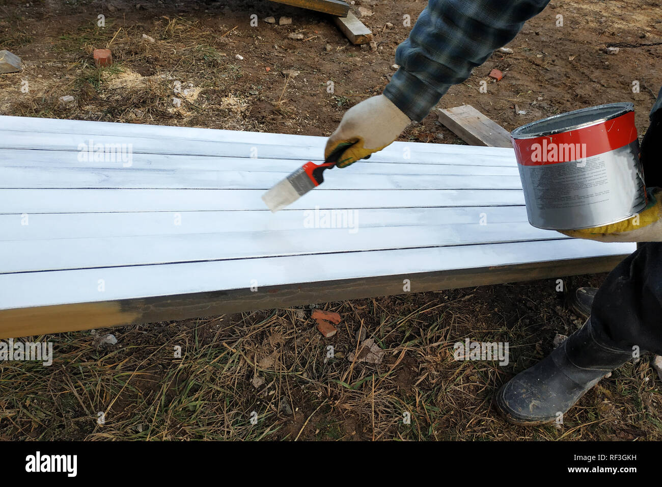 The process of painting pine wood panels with a brush and white paint ...