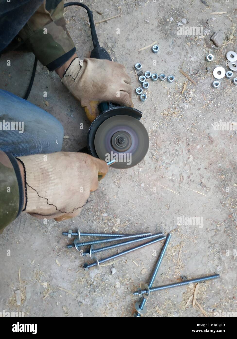 the worker uses an angle grinder to sharpen the bolts, a close-up plan ...
