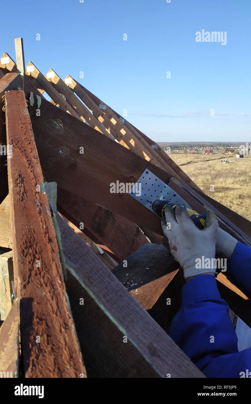The worker screw the screw into a screw plate, a roof rack of the ...