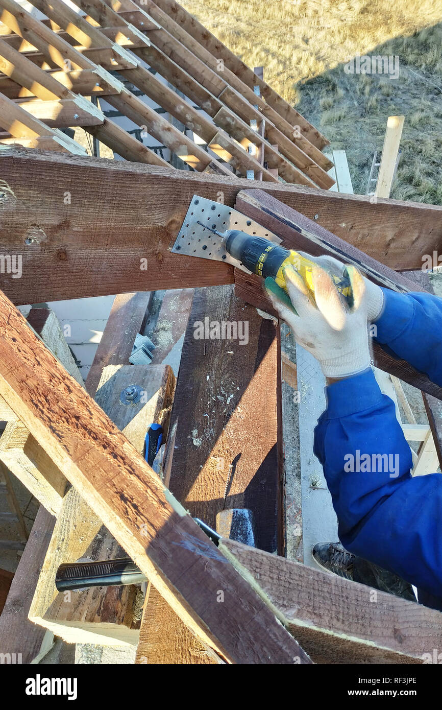 The worker screw the screw into a screw plate, a roof rack of the ...