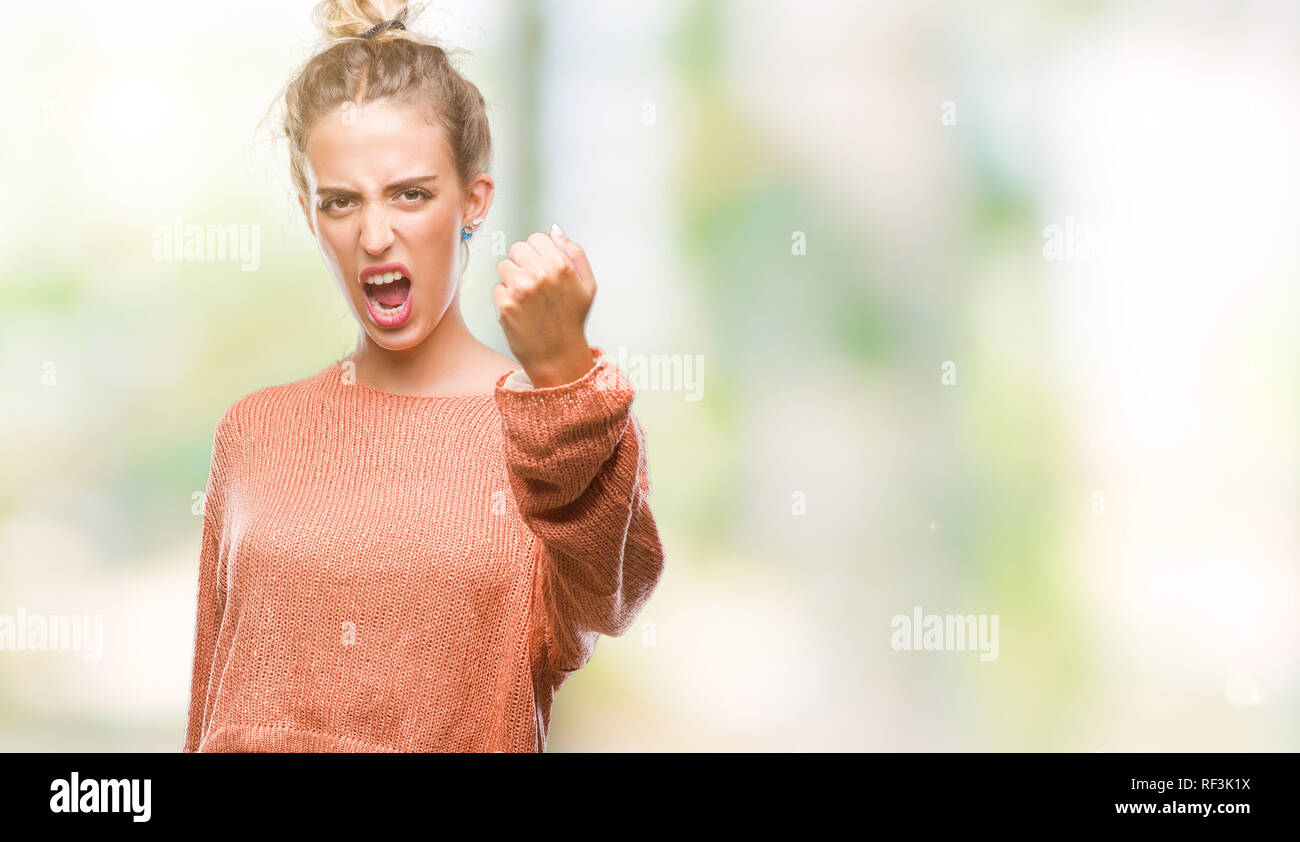 Beautiful young blonde woman over isolated background angry and mad ...