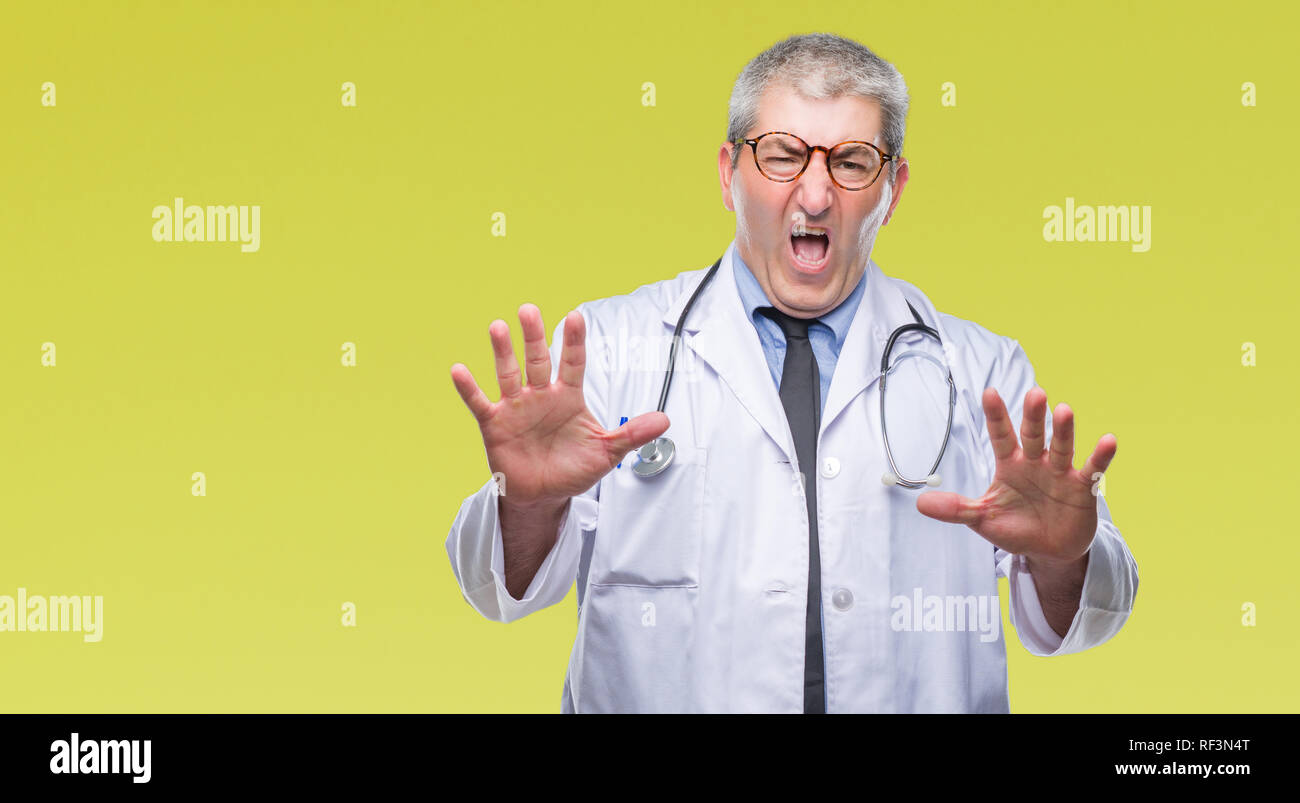 Handsome senior doctor man over isolated background afraid and ...