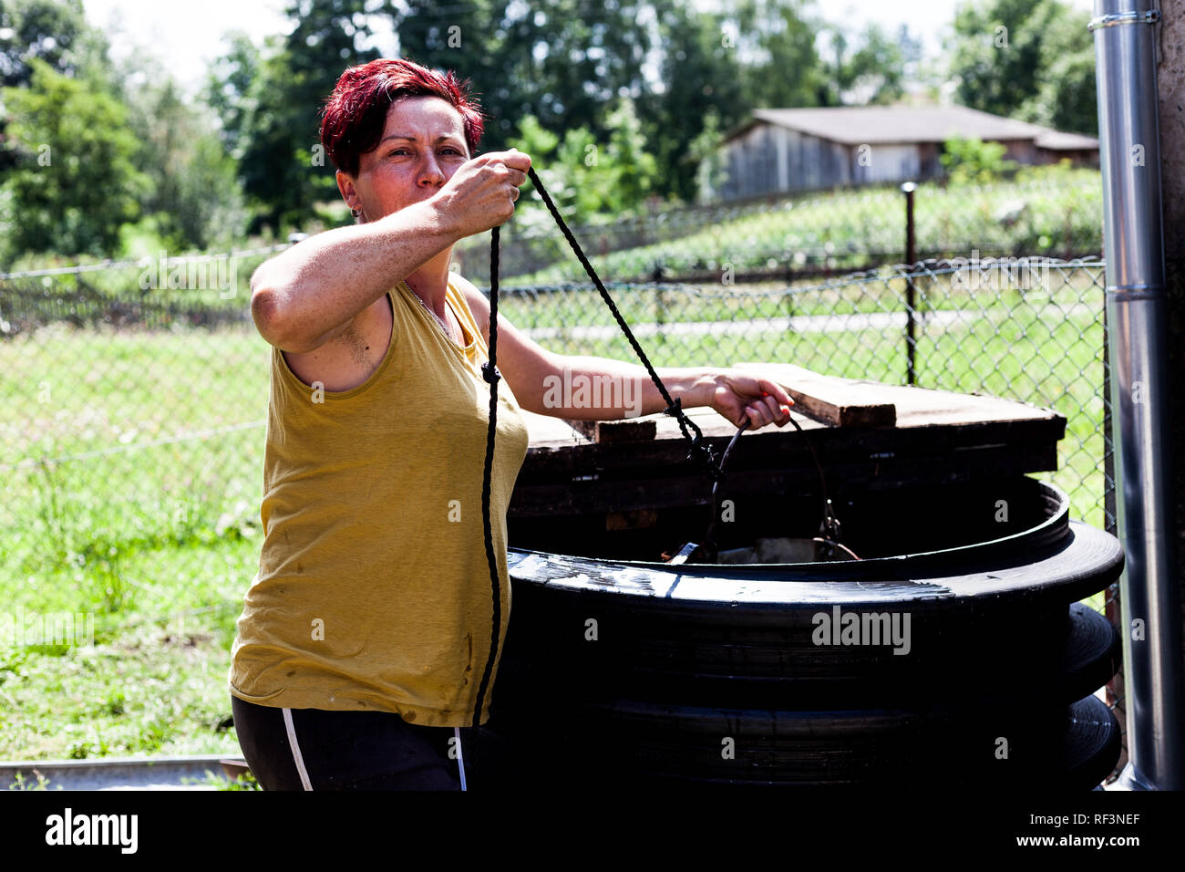 View of a woman pulling a metal bucket through the string. The ...