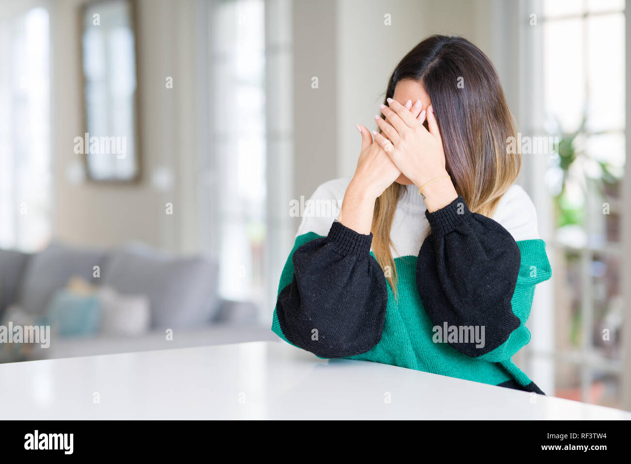 Young beautiful woman wearing winter sweater at home with sad ...