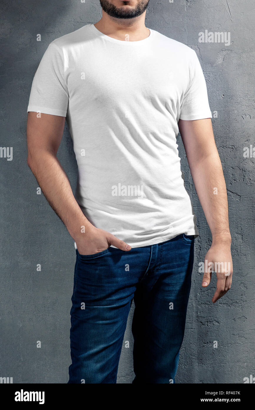 Young healthy man with white T-shirt on concrete background. Picture ...
