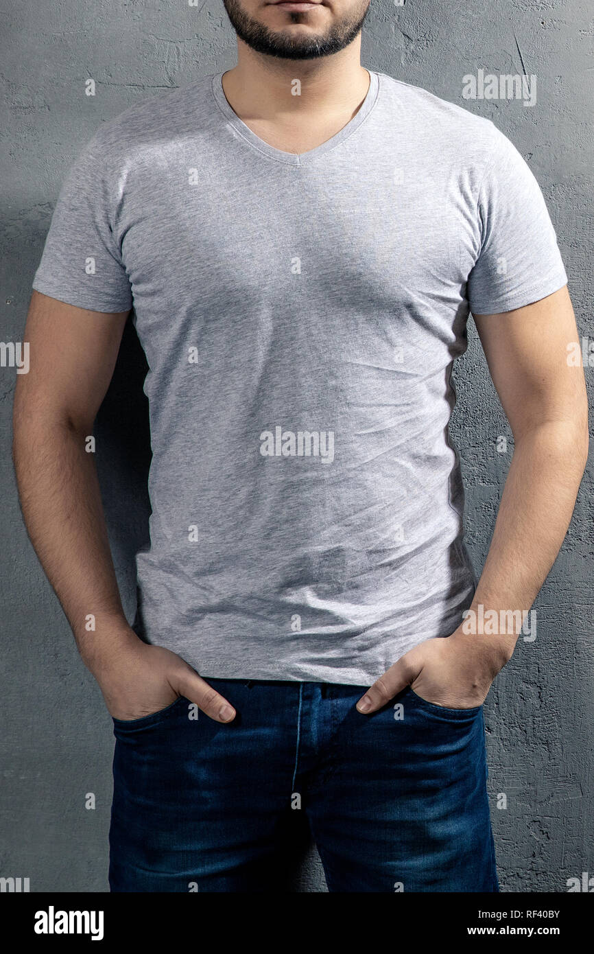 Young healthy man with grey T-shirt on concrete background. Picture ...