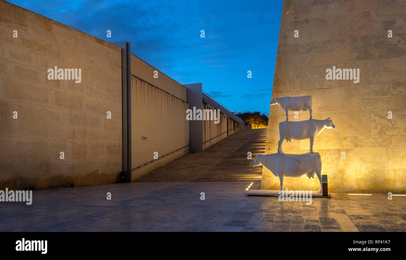 A sculpture of three cows on top of each other in the Maltese capital ...