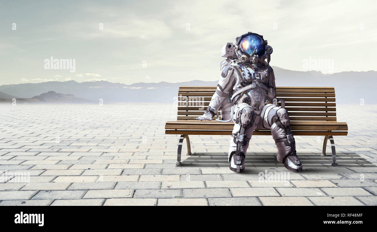 Spaceman sitting on wooden bench. Mixed media Stock Photo - Alamy