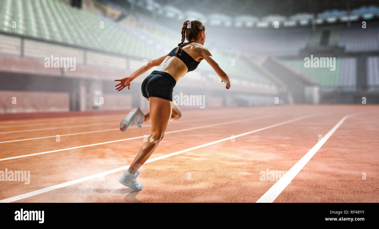 Athletic woman running on track at stadium. Mixed media Stock Photo - Alamy