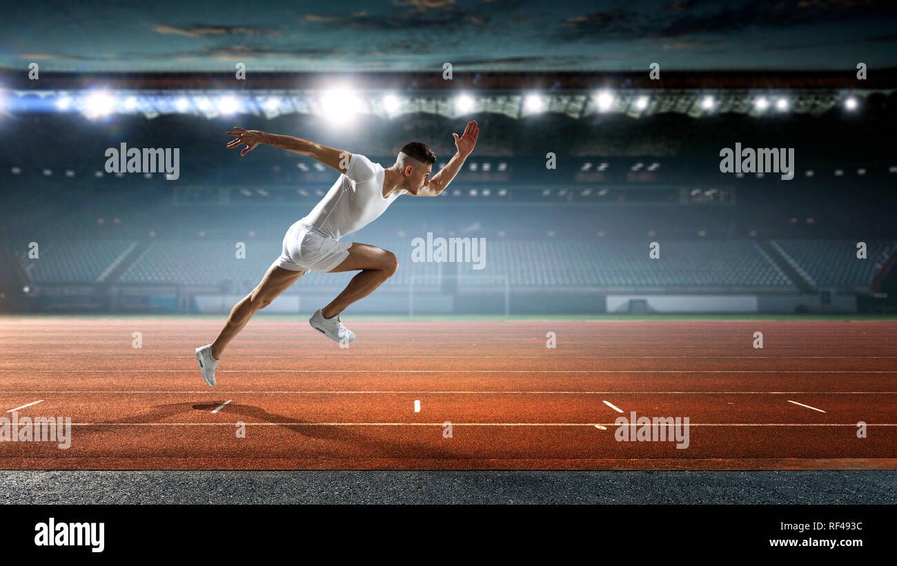 Athlete man running on racetrack at stadium mixed media hi-res stock ...