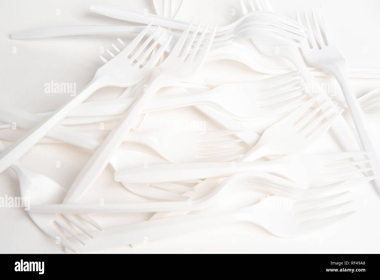 A bunch of white disposable single-use plastic forks commonly available ...