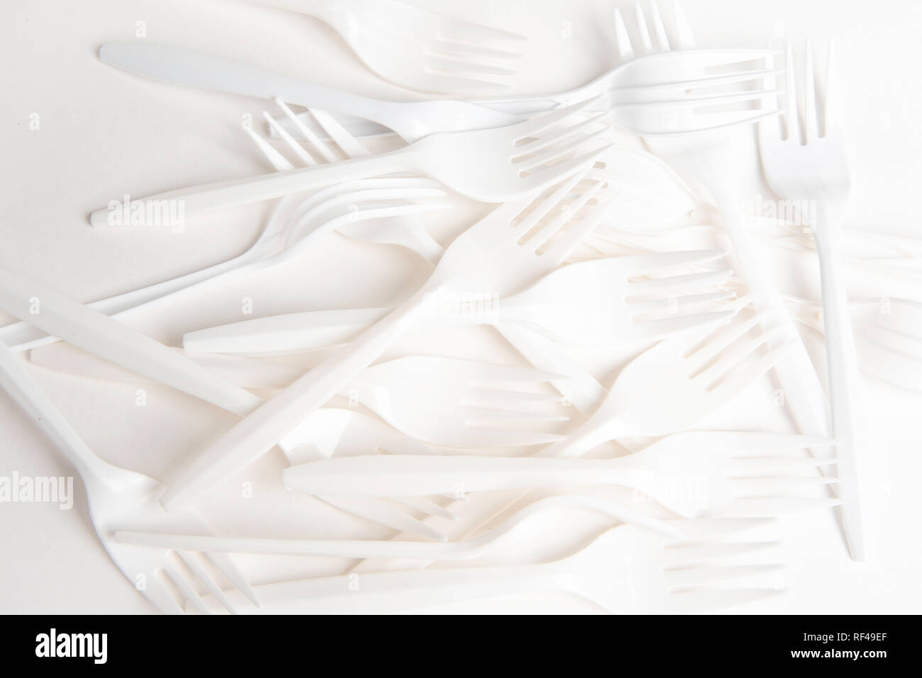 A bunch of white disposable single-use plastic forks commonly available ...