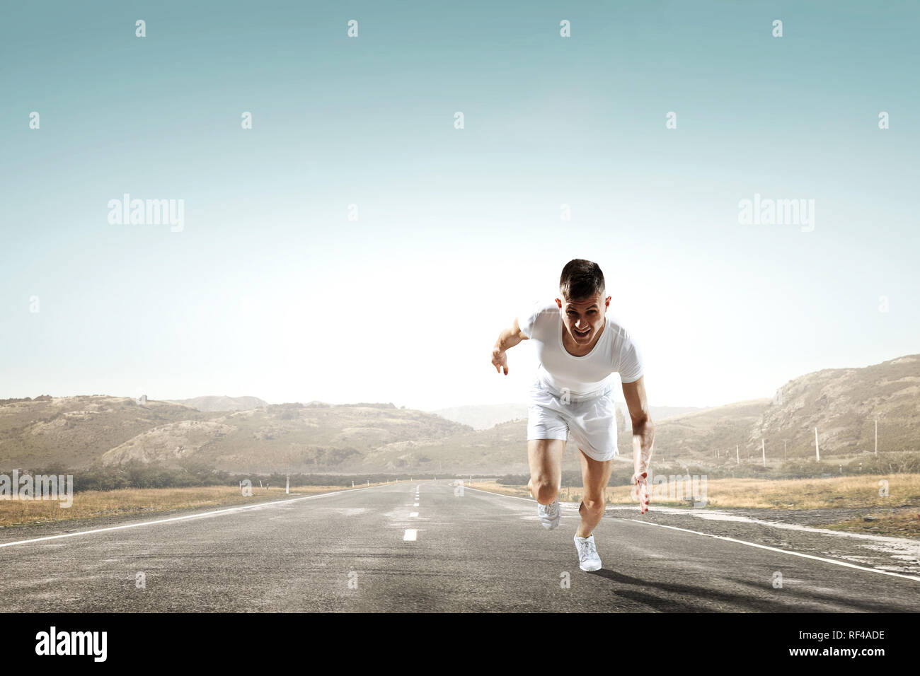 Young sportsman running on asphalt road. Mixed media Stock Photo - Alamy