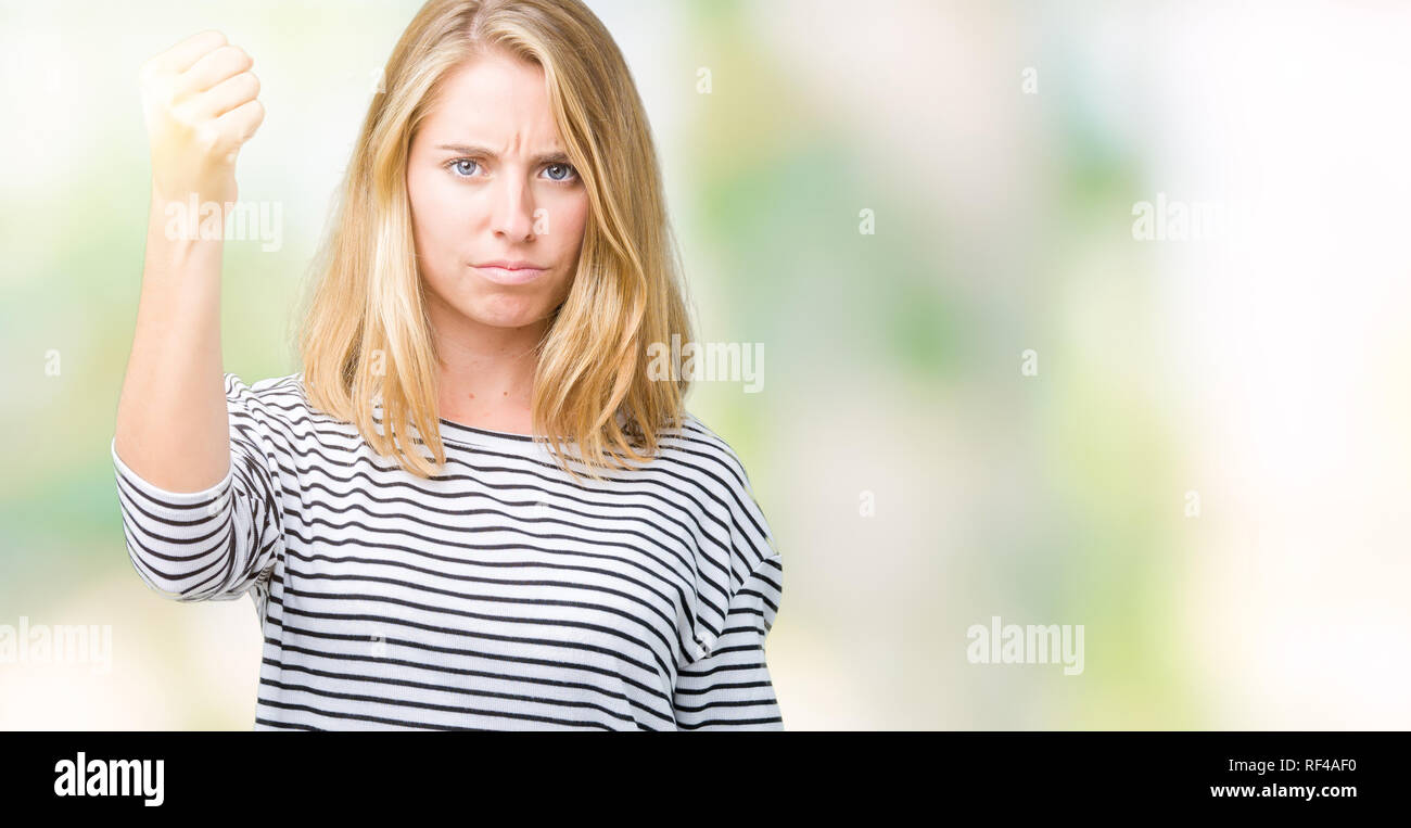 Beautiful young woman wearing stripes sweater over isolated background ...