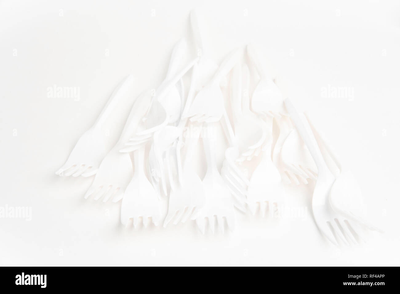 A bunch of white disposable single-use plastic forks commonly available ...
