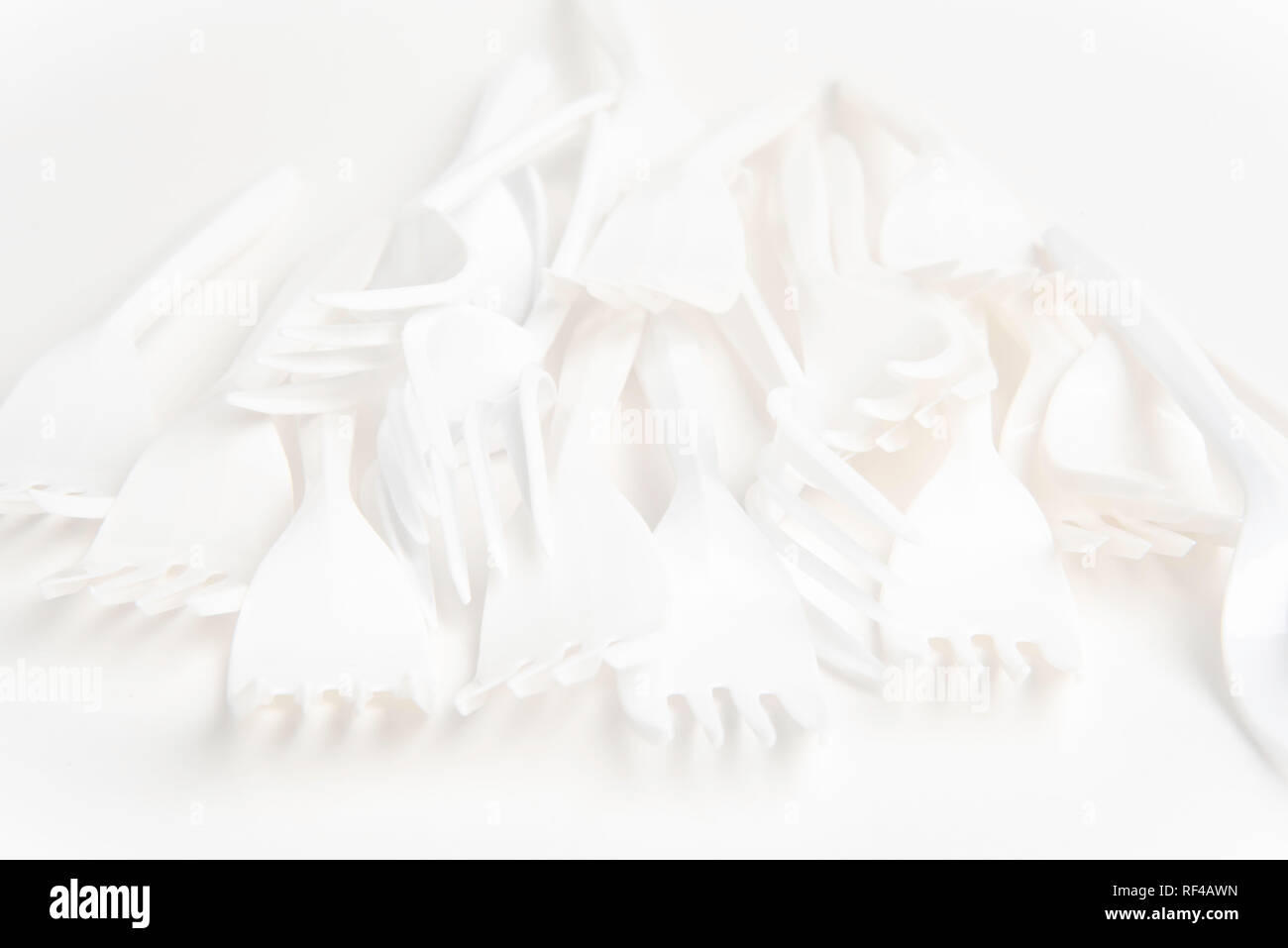 A bunch of white disposable single-use plastic forks commonly available ...