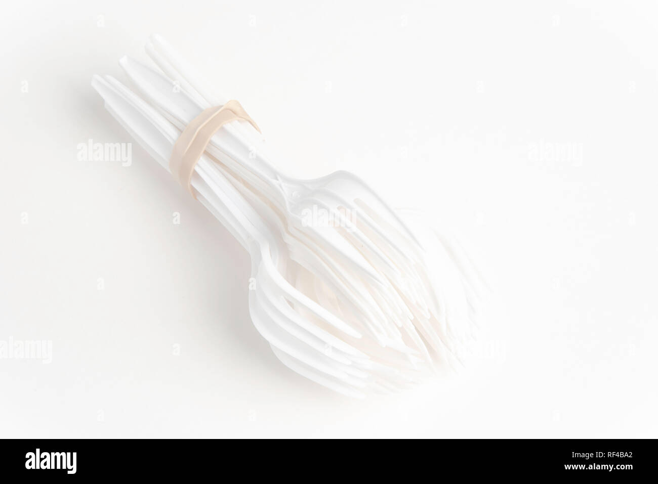 A bunch of white disposable single-use plastic forks commonly available ...