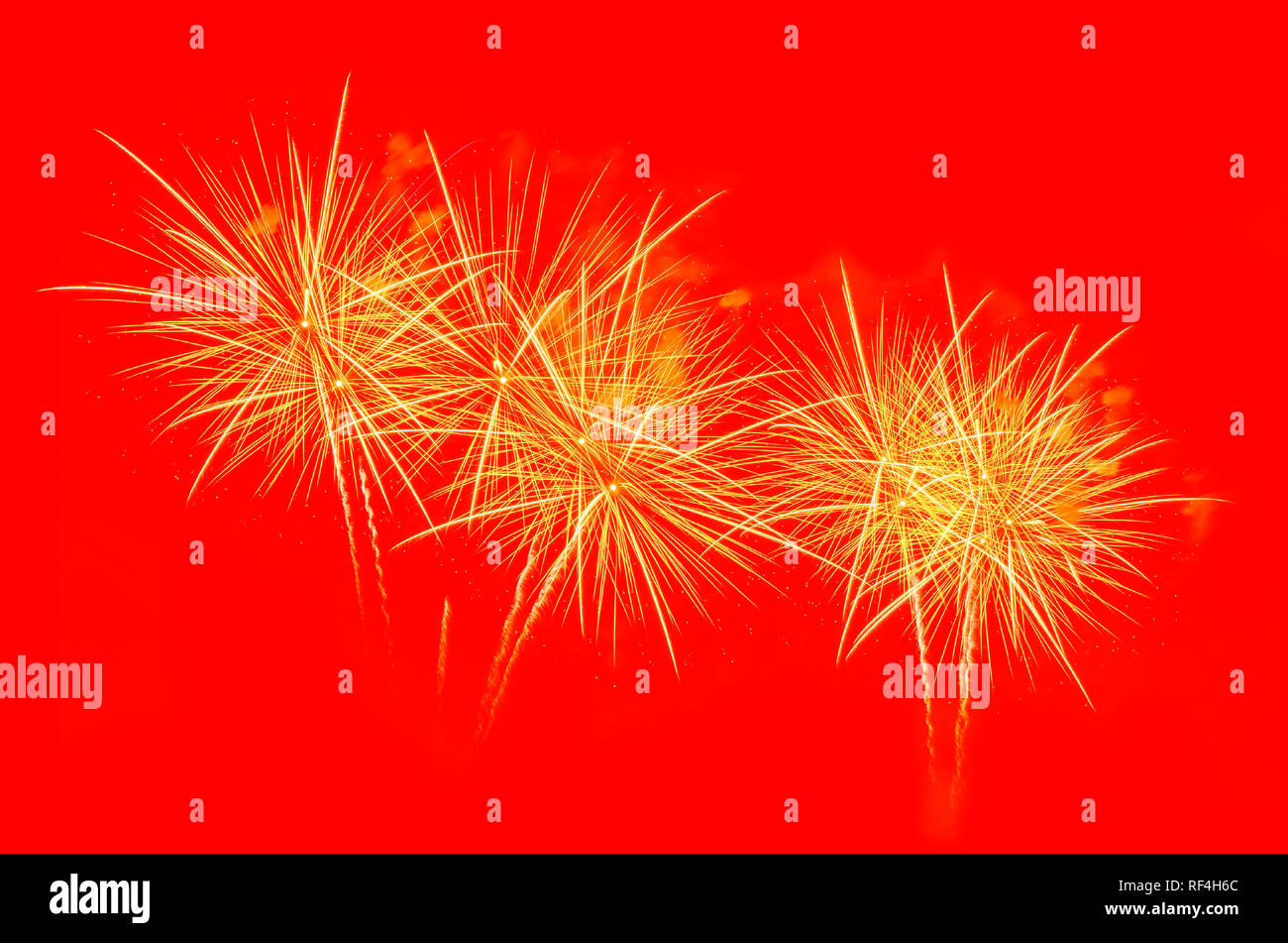 Gold fireworks celebration on red background Stock Photo - Alamy