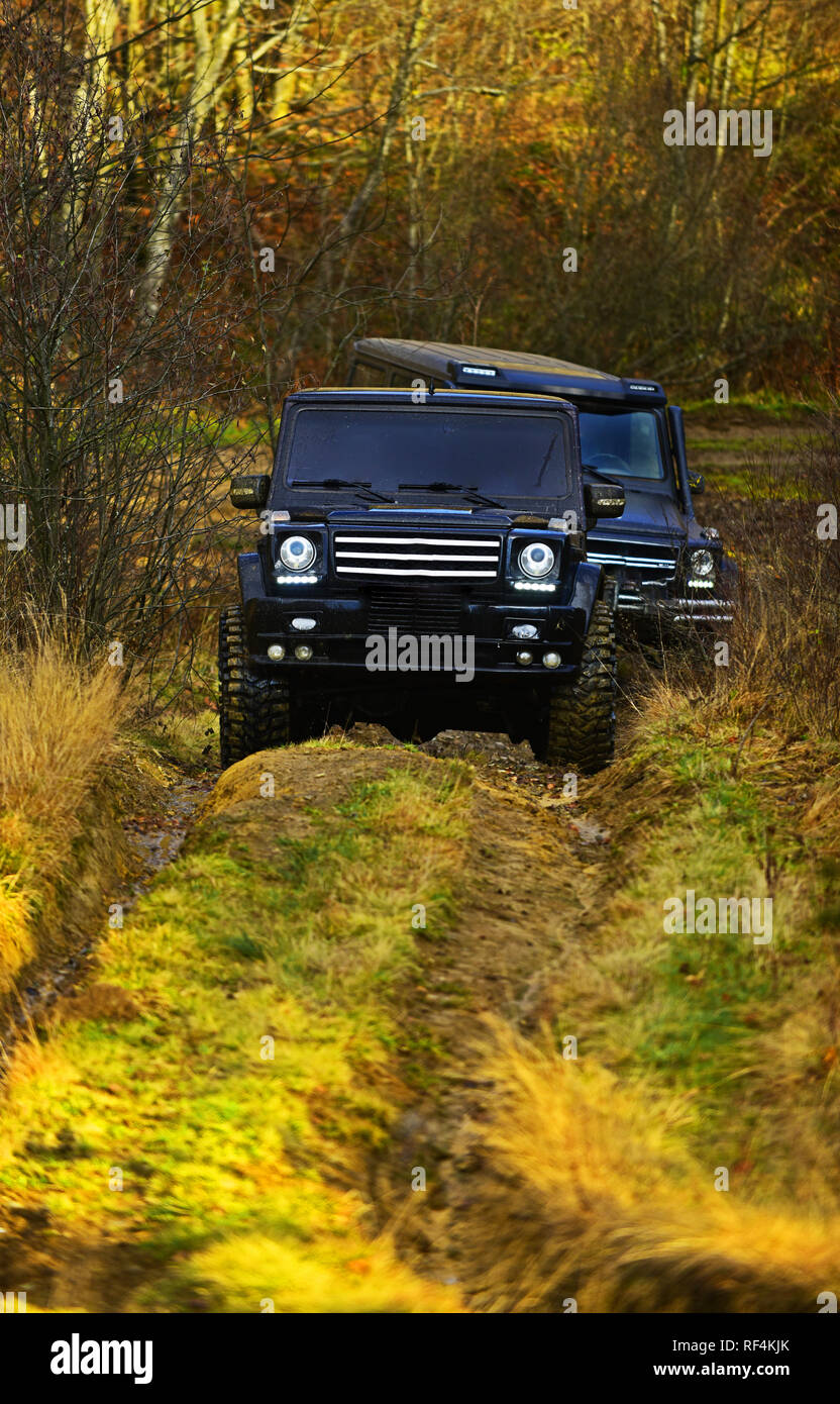 SUV or two black offroad cars on fall nature background. Offroad race ...