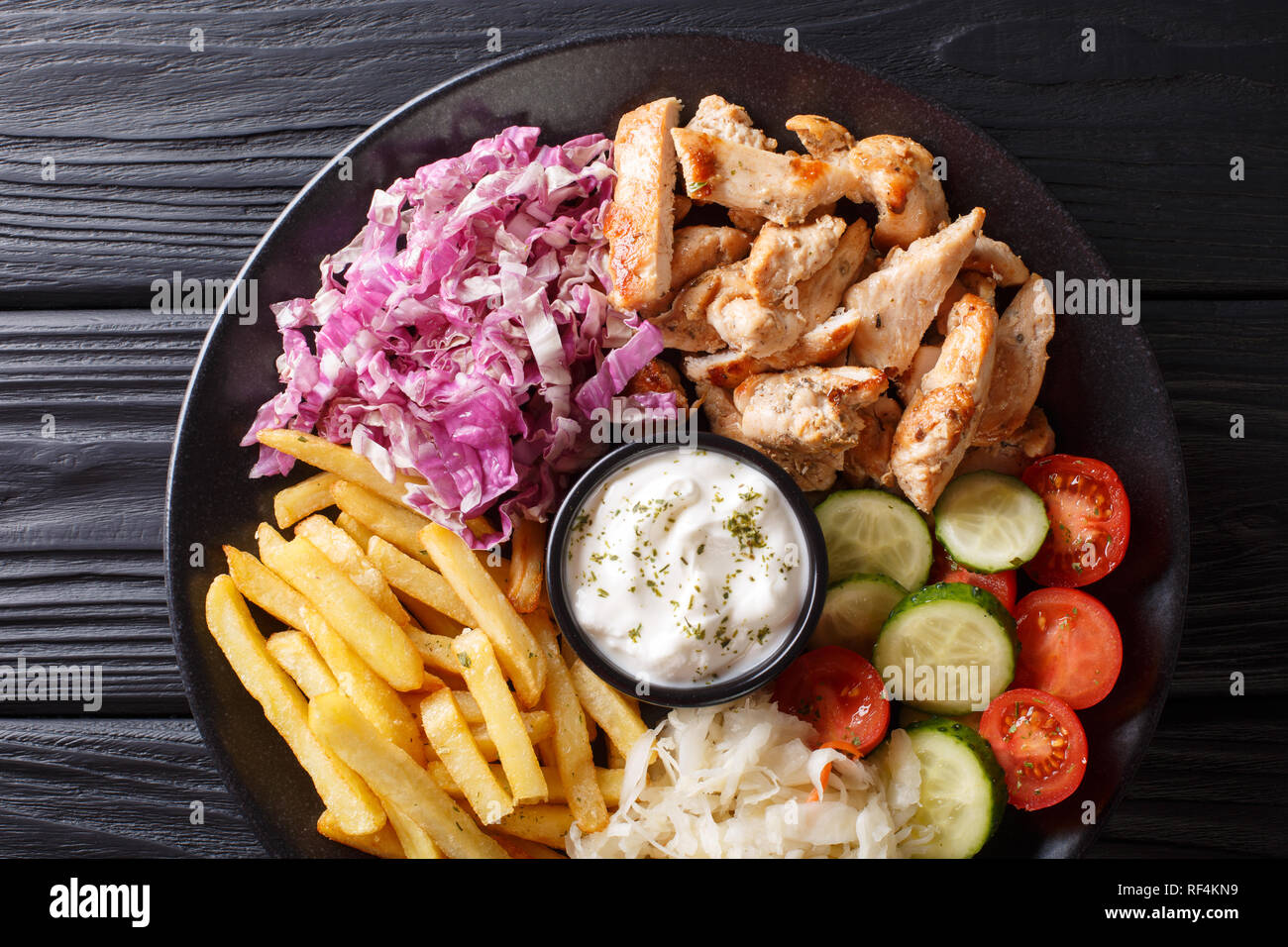 Chicken shawarma with vegetables and sauce serving on a plate close-up ...