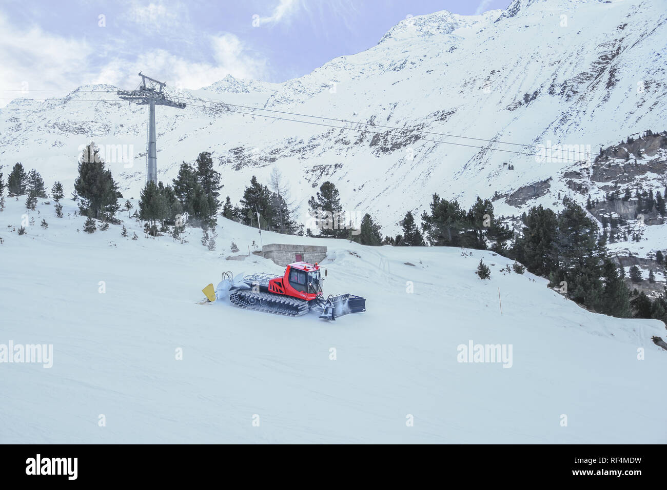 Red bully pisten on winter snow mountain with ski cable and top ...