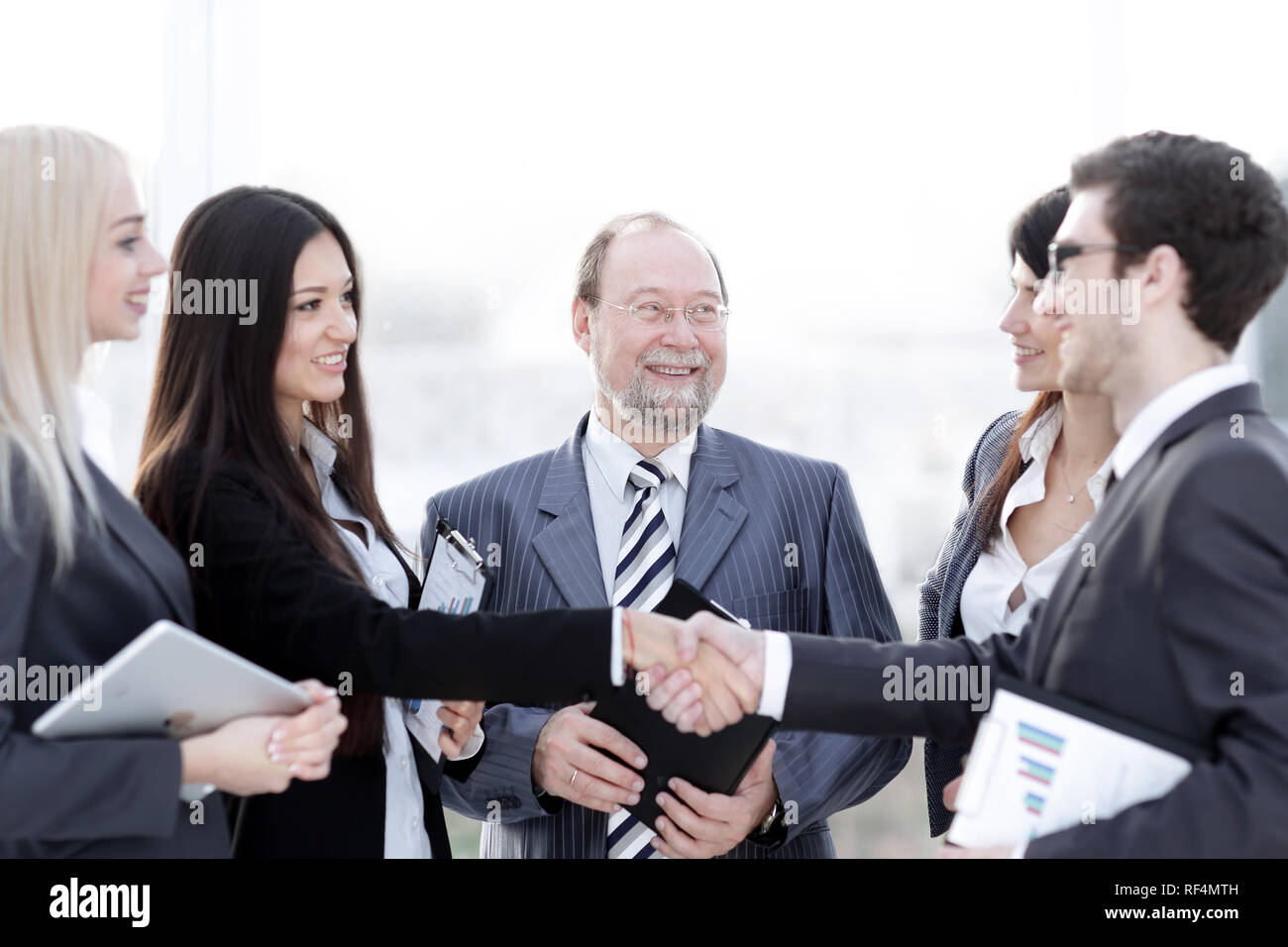 professional business team and shaking hands of young business partners in the office Stock ...