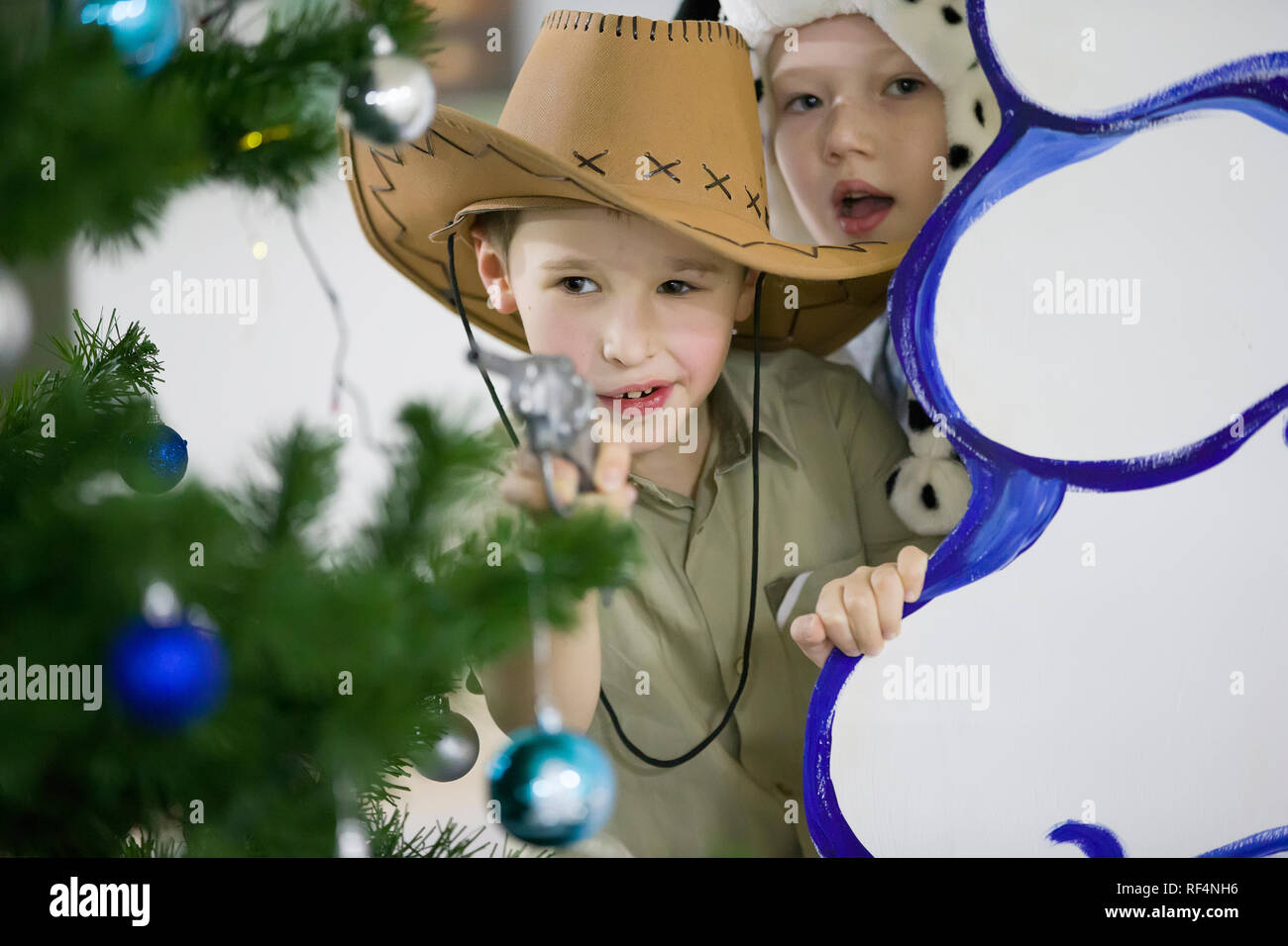 A child with a gun in a new year cowboy costume.Children's New Year's ...
