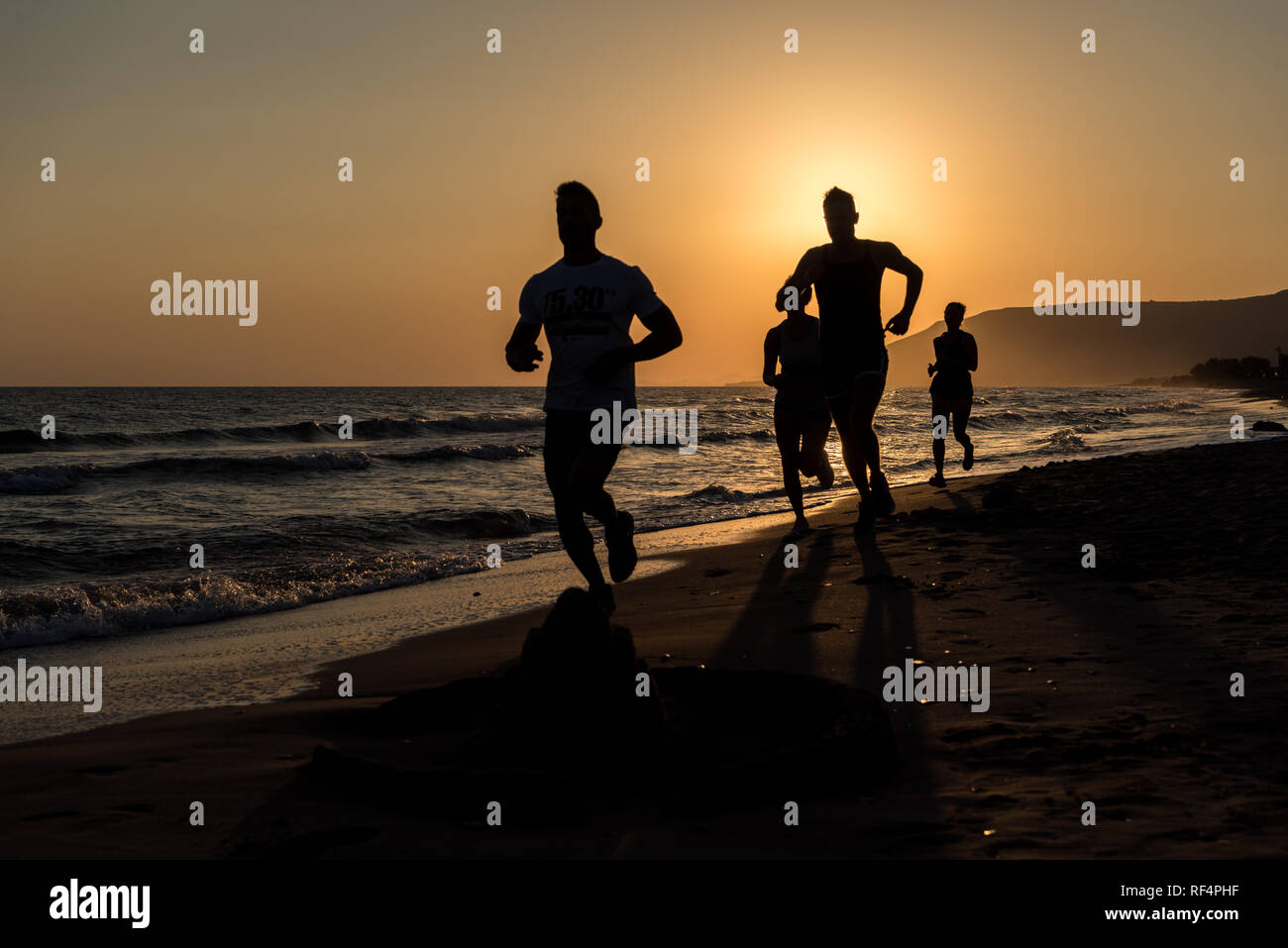 People running on the beach in the morning Stock Photo - Alamy
