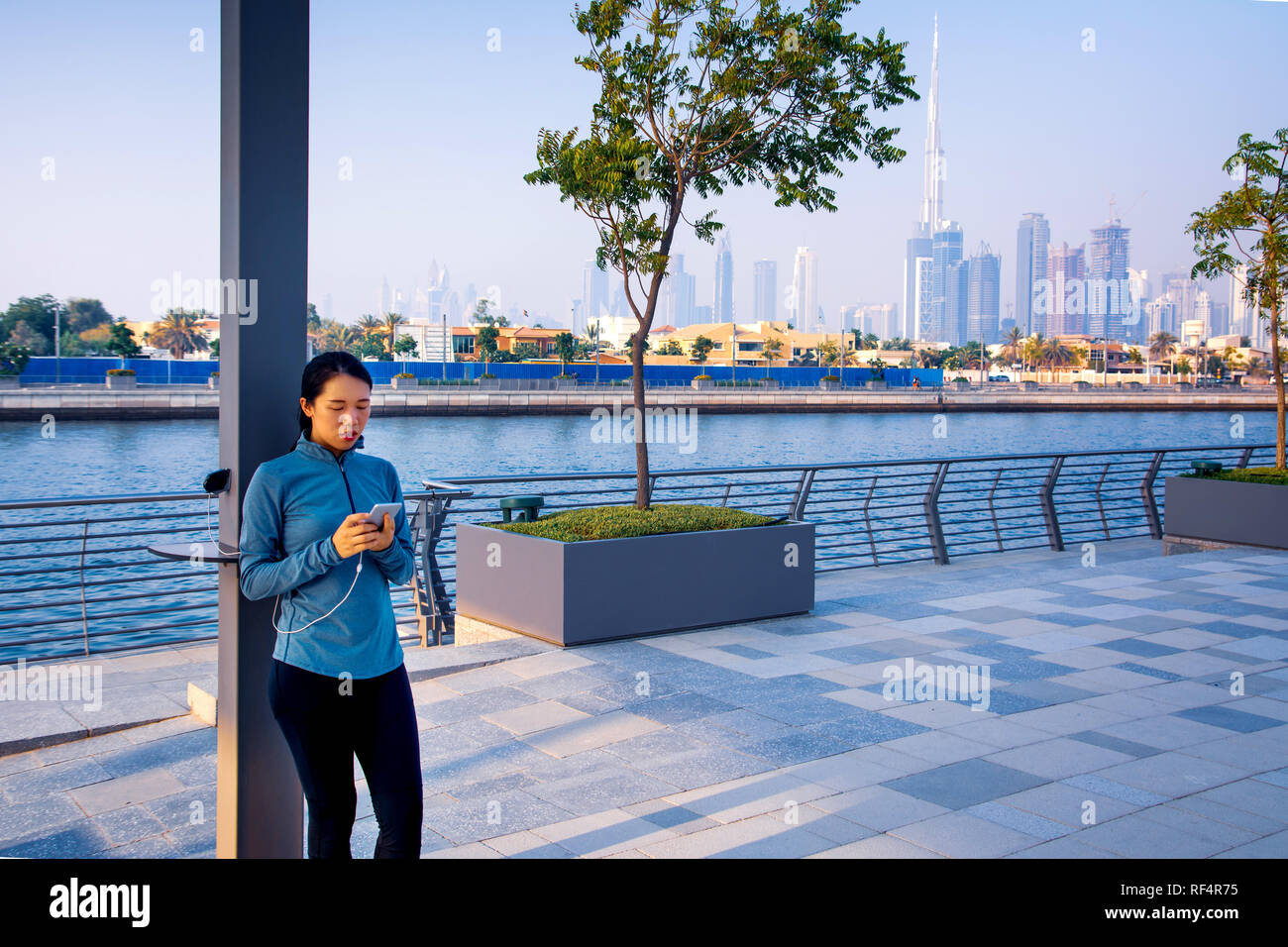 Female using phone and charging on a public charger Stock Photo - Alamy