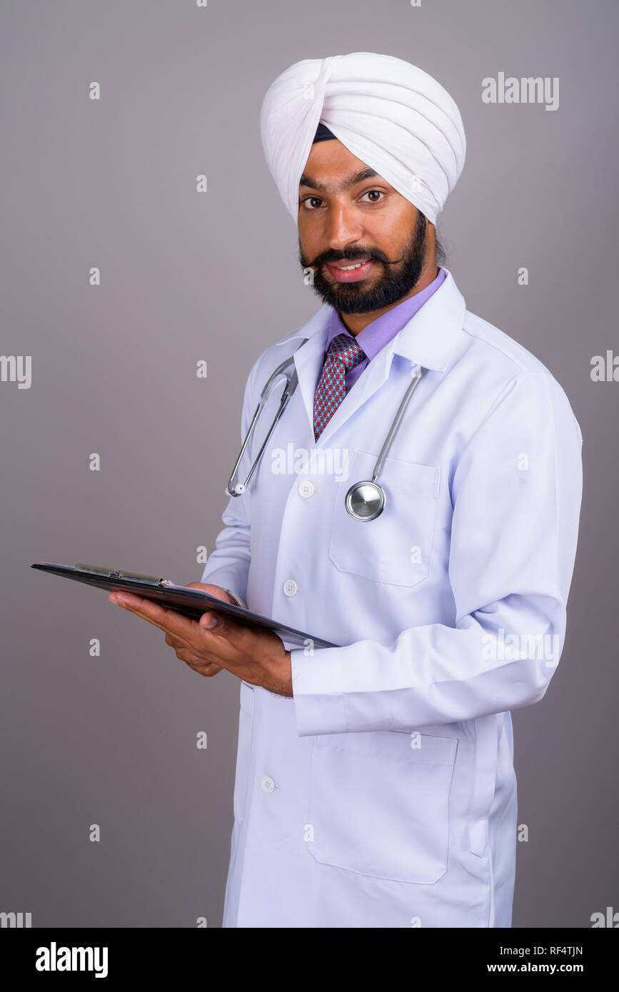 Portrait of young Indian Sikh man doctor holding clipboard Stock Photo ...